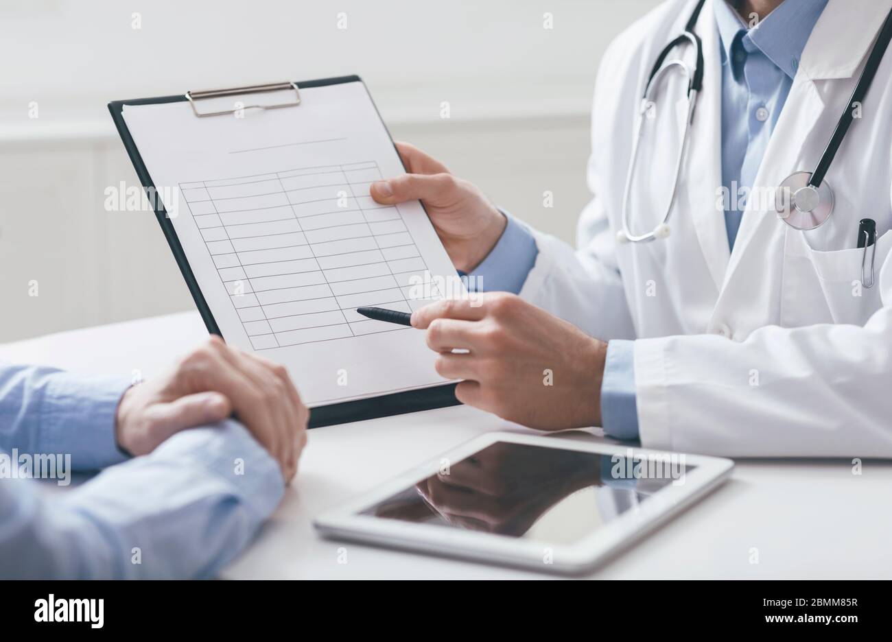 Doctor showing treatment plan to senior patient at hospital Stock Photo ...