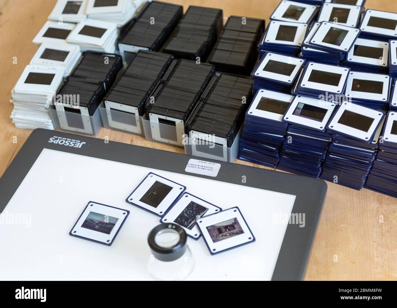 Piles of film transparency slides and Lightbox with viewing enlarger ...