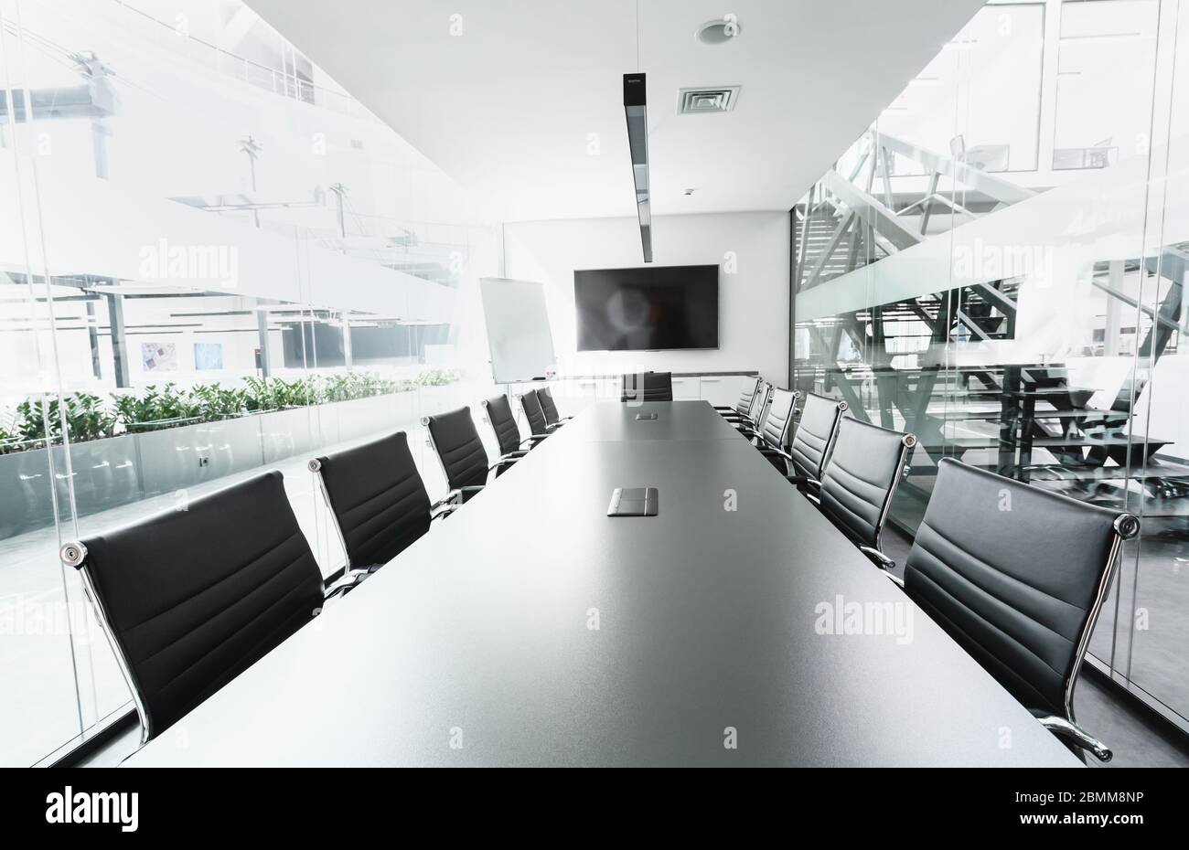 Long table in conference hall with TV, transparent walls Stock Photo ...