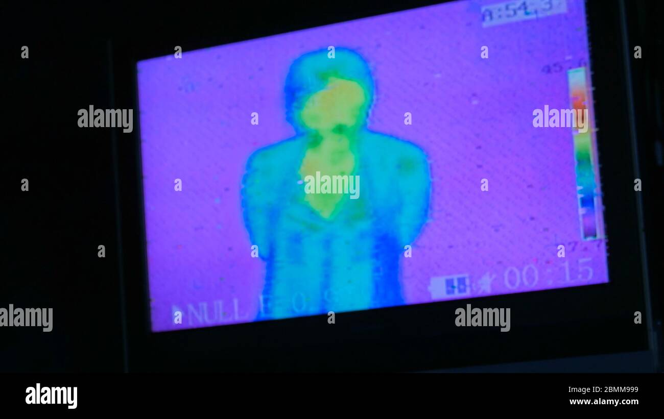 Thermographic camera view of woman. Blue, green, yellow colors show ...