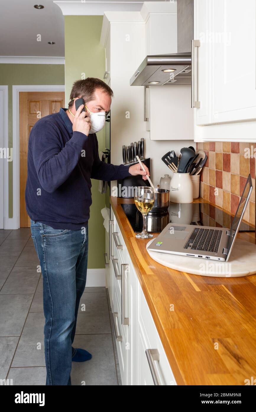 Man cooking in the kitchen while working from home during the covid 19 ...