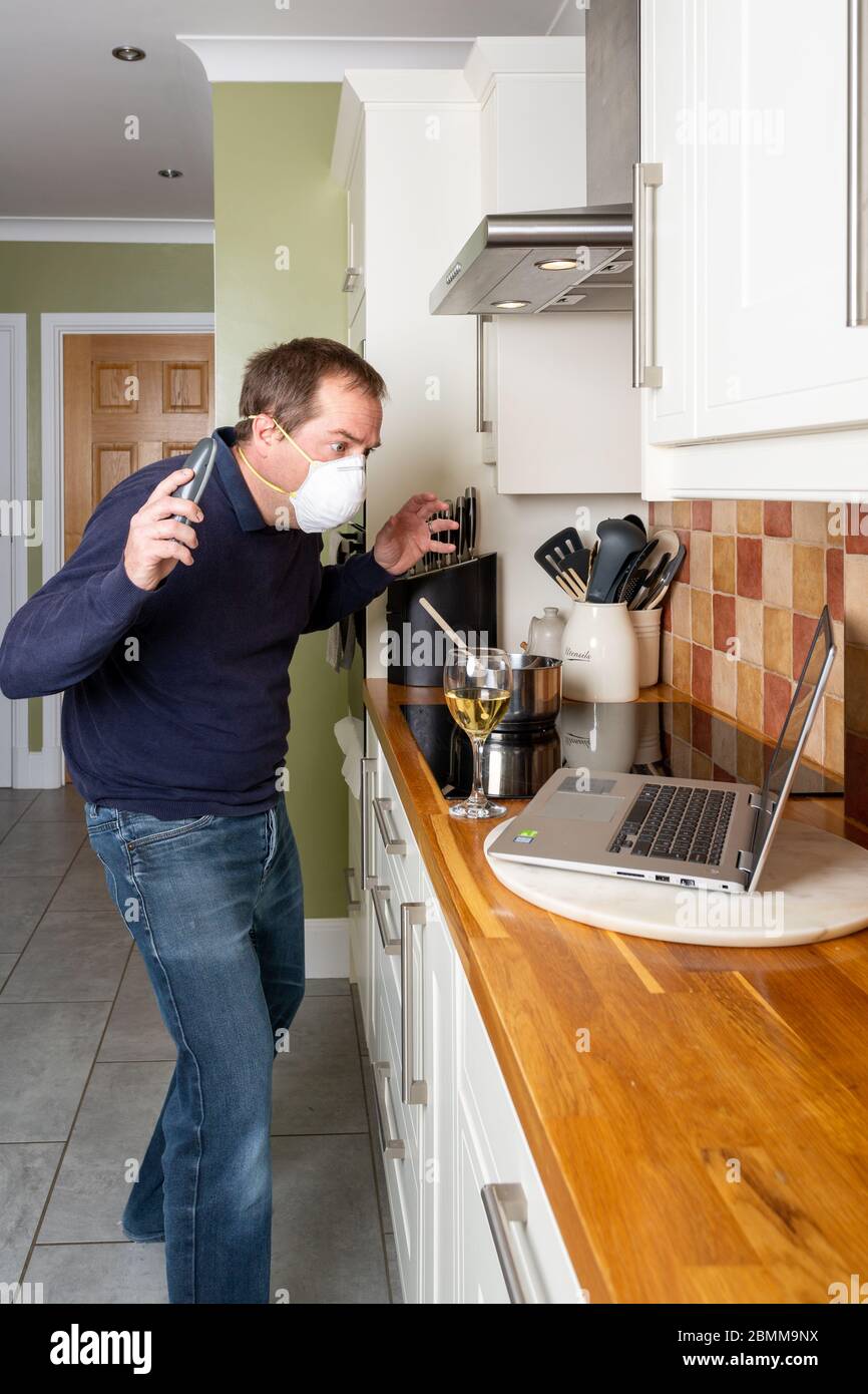 Man cooking in the kitchen while working from home during the covid 19 ...