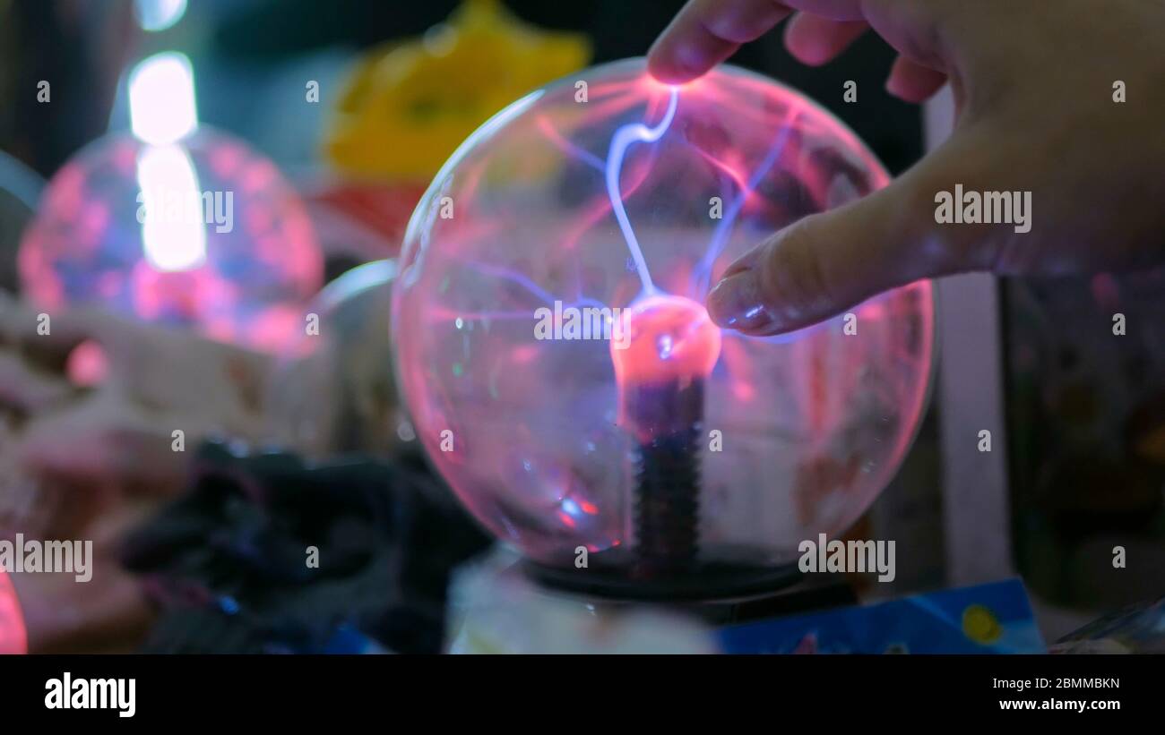 Woman hand touching plasma ball at technology exhibition. Physics ...