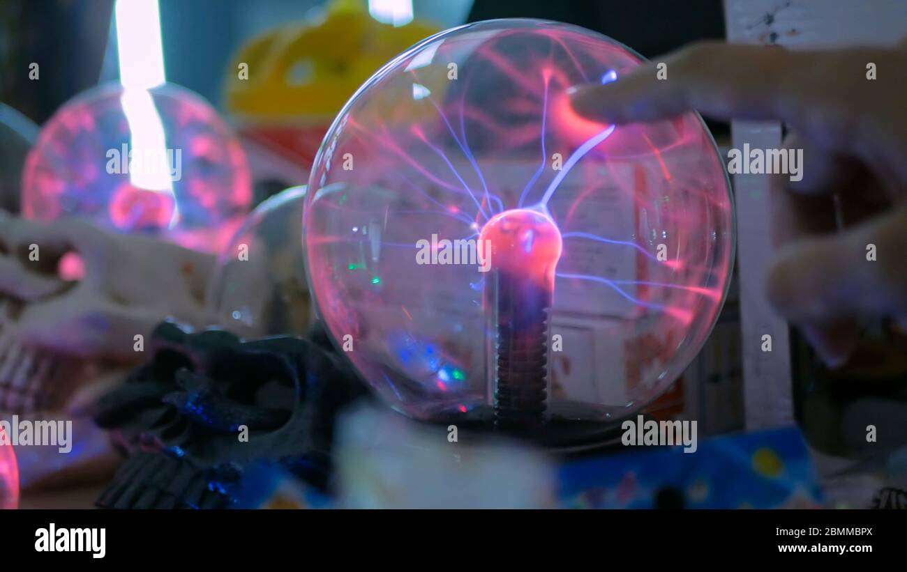 Woman hand touching plasma ball at technology exhibition. Physics ...