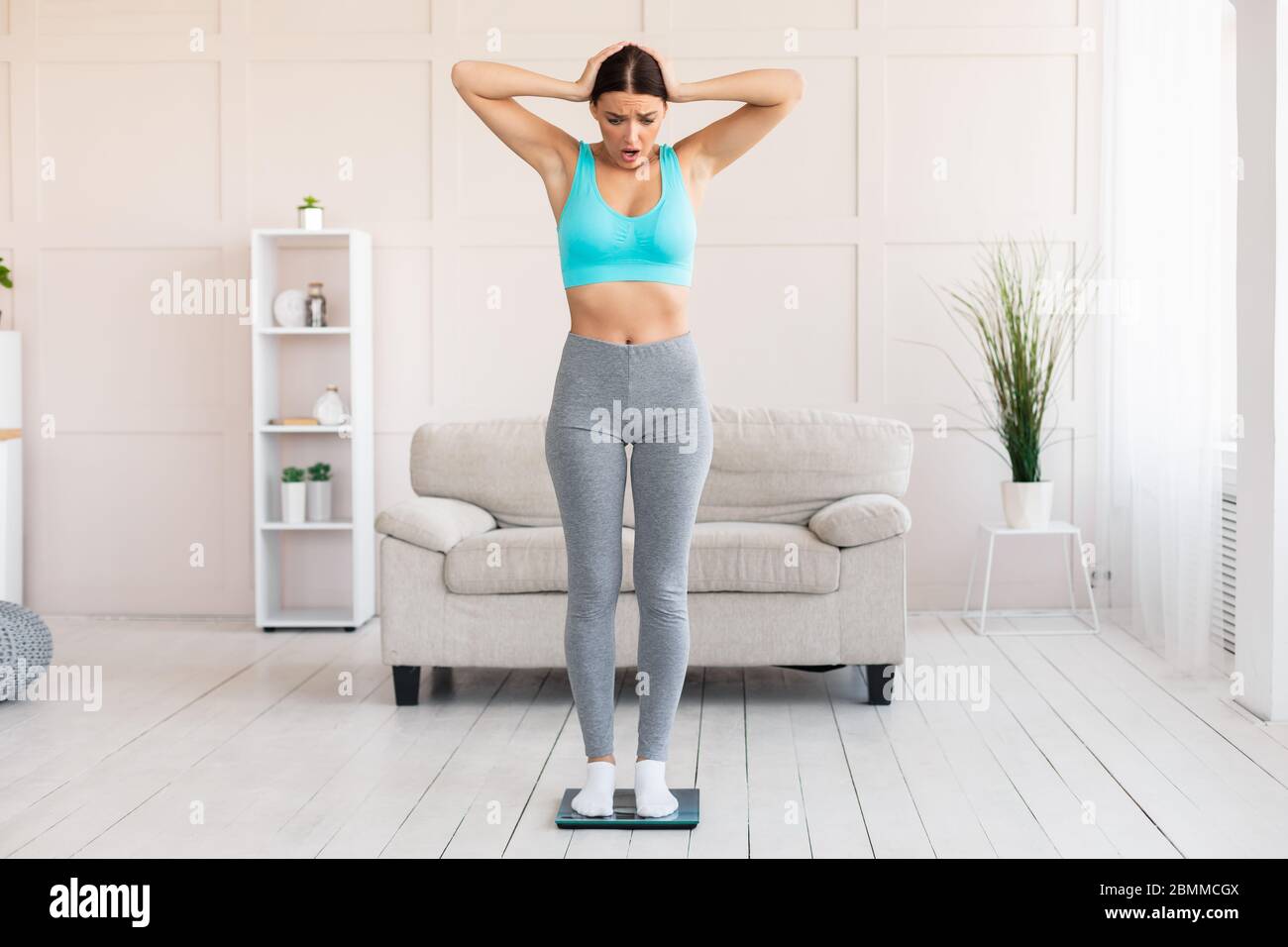 Shocked Woman Standing On Weight Scales Gaining Kilograms At Home Stock ...