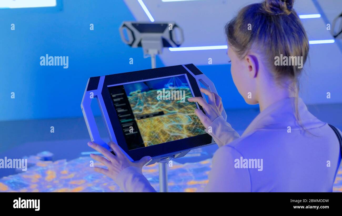 Woman using interactive touchscreen display with virtual map of Moscow ...