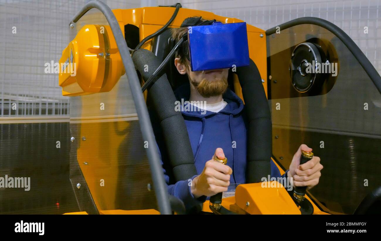 Young man playing virtual reality space battle simulator at technology ...