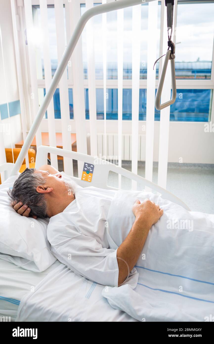 Senior male patient in a modern hospital. Getting better after a ...