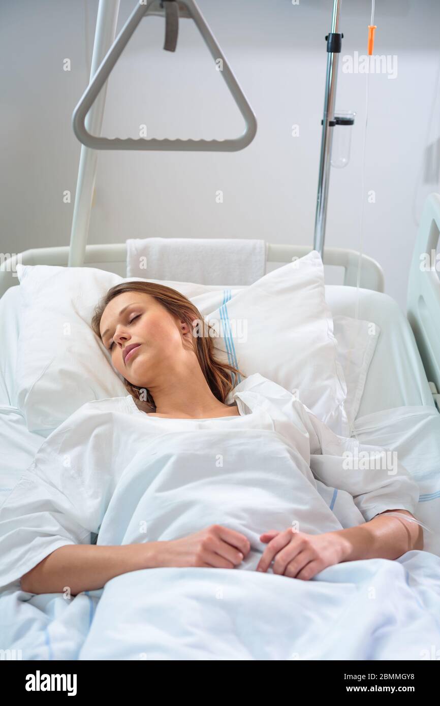 Pretty, young female patient in a modern hospital room. Getting better ...