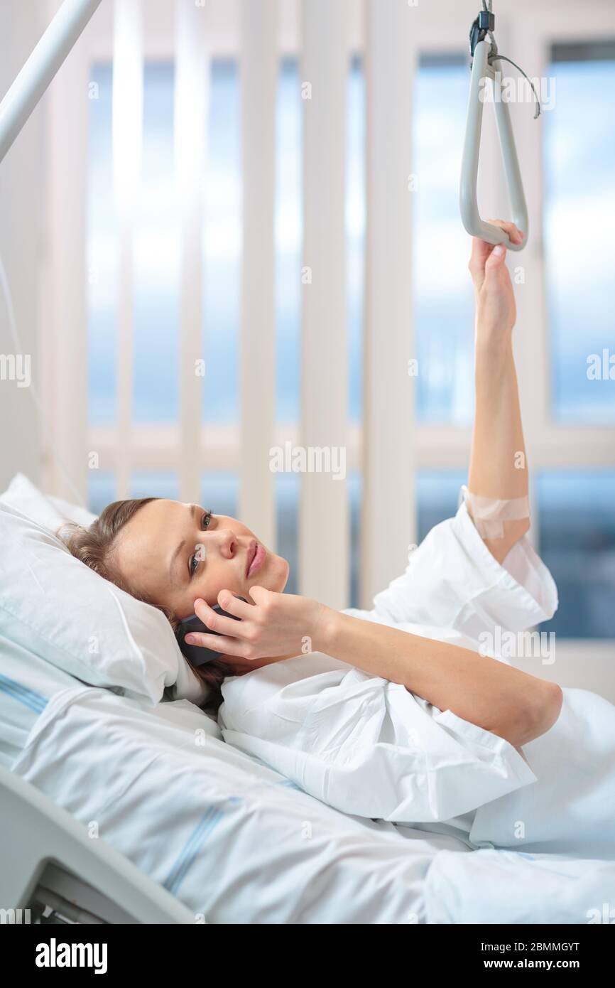 Pretty, young, female patient in a modern hospital room. Getting better ...