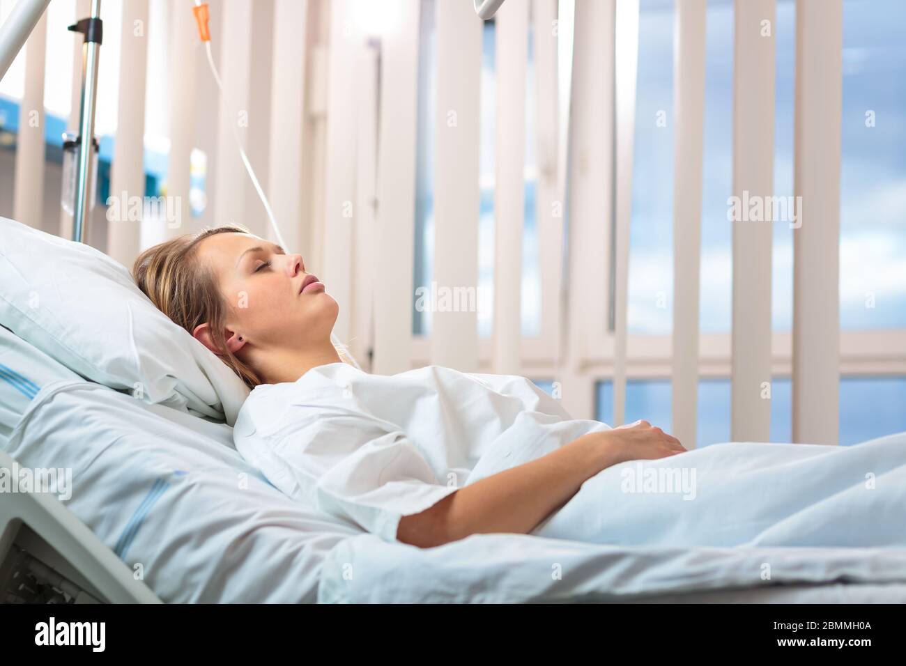 Pretty, young, female patient in a modern hospital room. Getting better ...