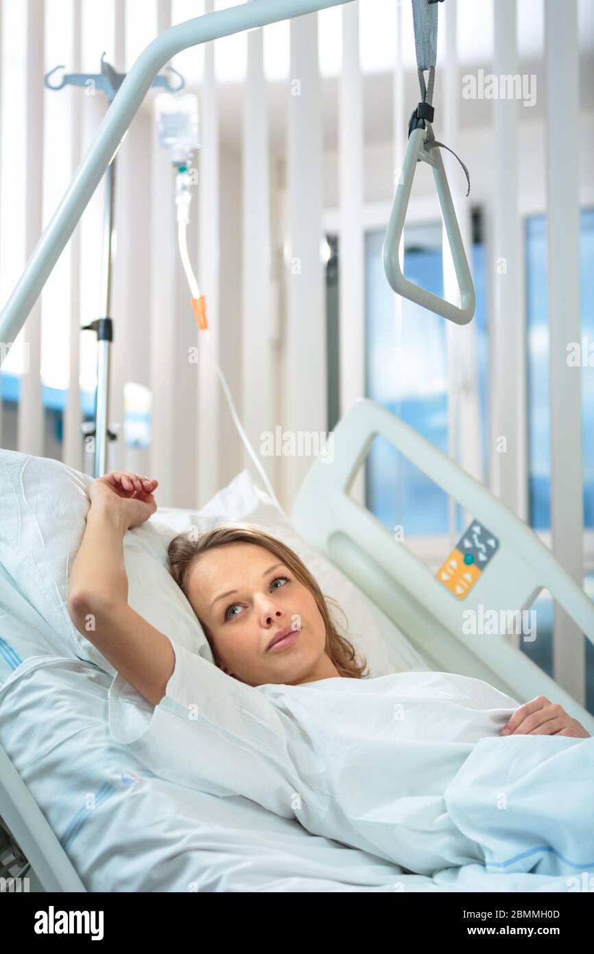 Pretty, young, female patient in a modern hospital room. Getting better ...