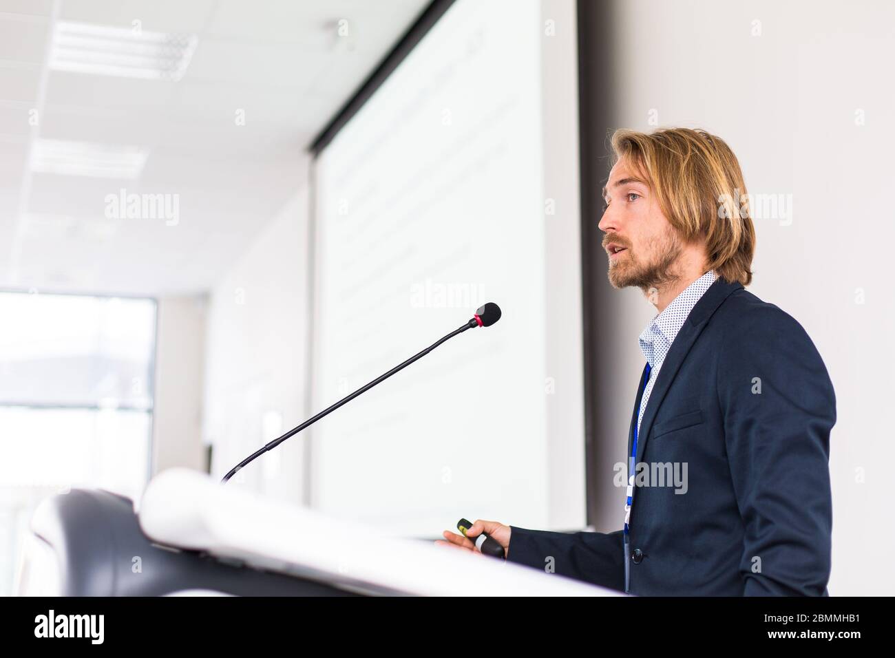 Handsome young man giving a speech at a conference Stock Photo - Alamy