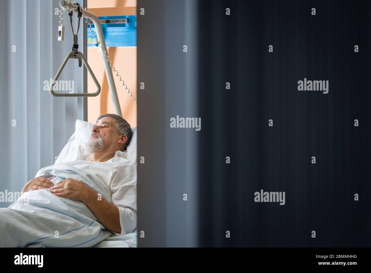 Senior male patient in a modern hospital. Getting better after a ...