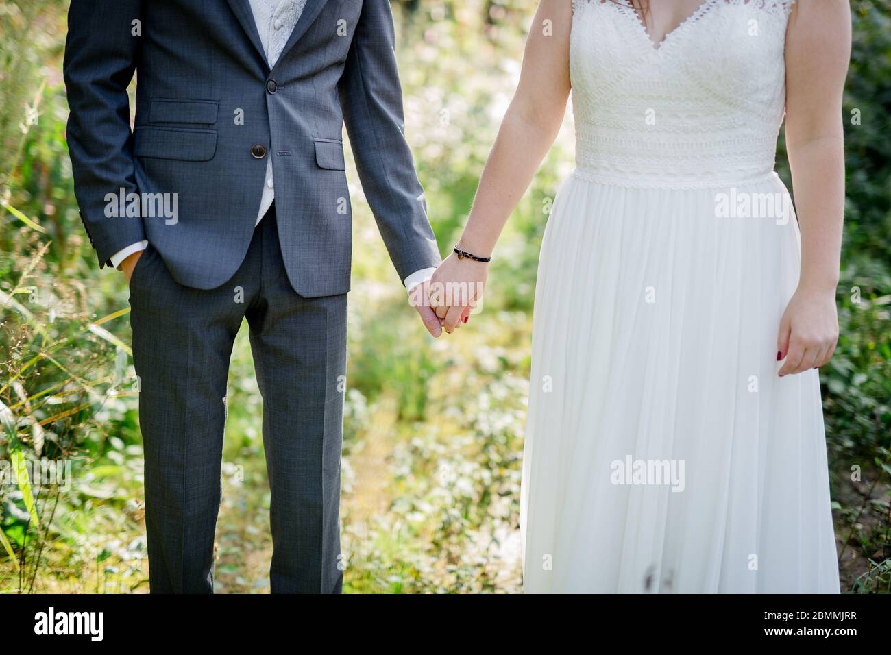 Bride and groom holding hands Stock Photo - Alamy