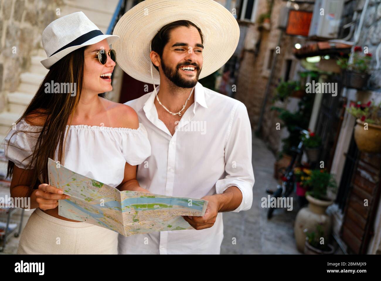 Happy tourists couple in love sightseeing city with map during summer ...