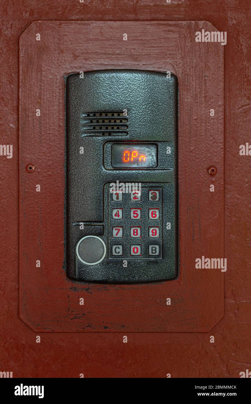 an intercom on old painted brown steel surface with a keypad, digital ...