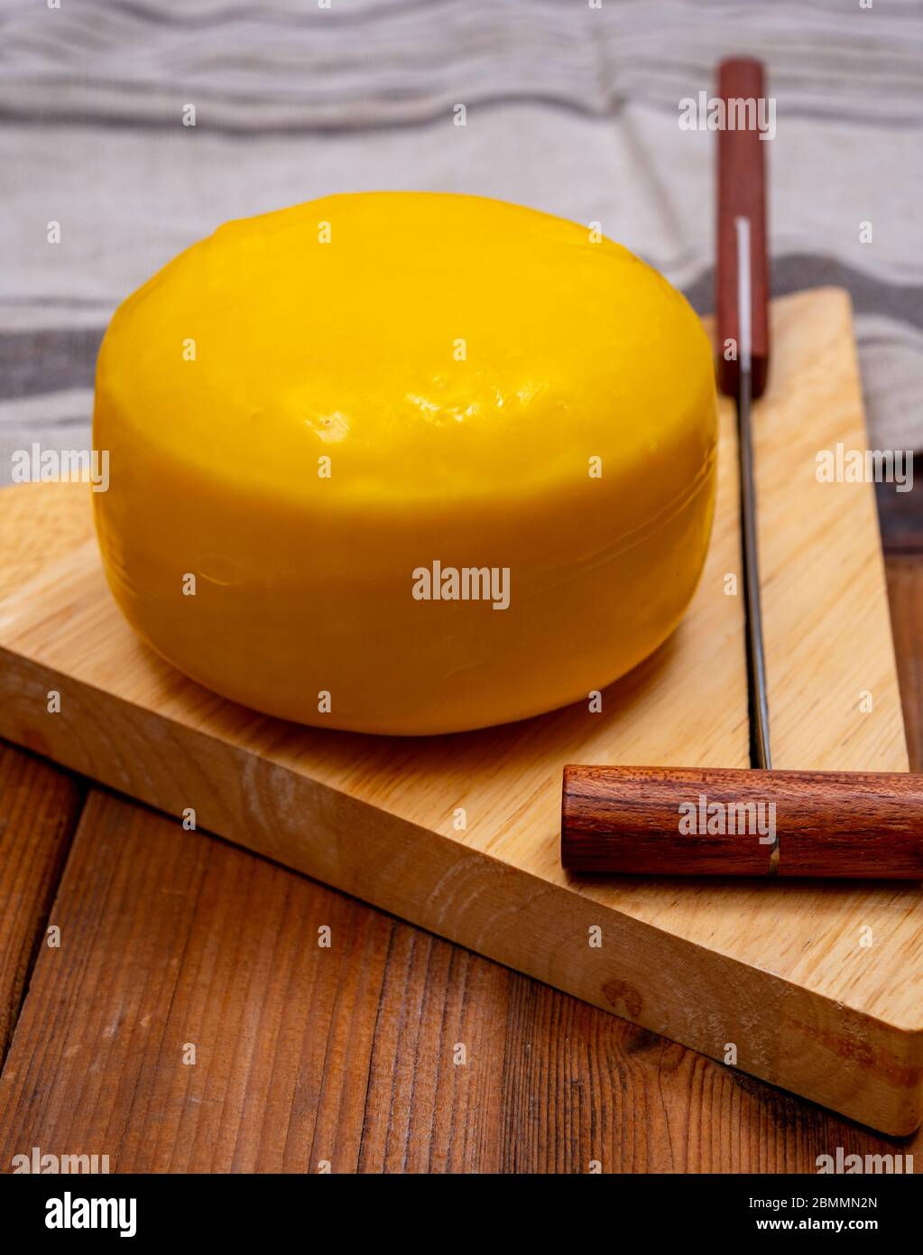 One small head of Dutch baby gouda cheese in yellow wax close up Stock ...