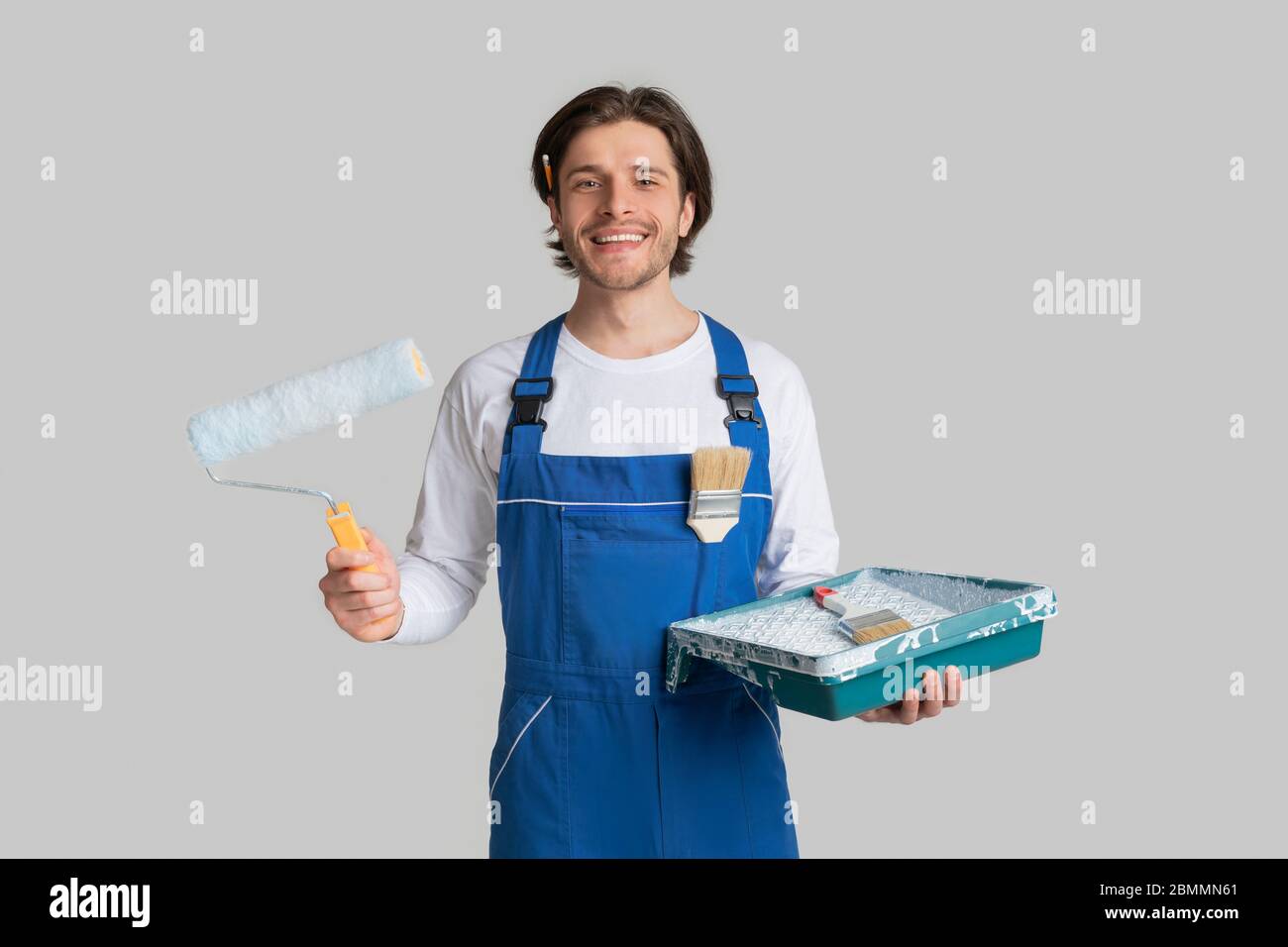 Renovation Services. Smiling Painter In Uniform With Painting Tools In ...