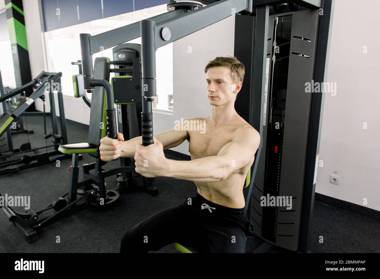 Bodybuilder posing in the gym. Handsome muscular man working out hard ...