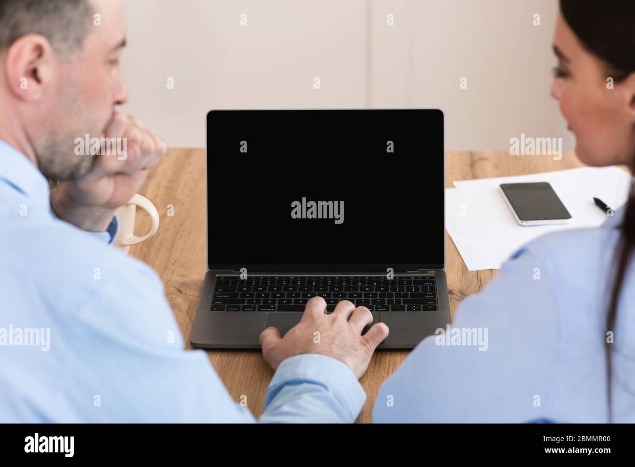Colleagues At Laptop With Empty Screen Working In Office, Back-View ...