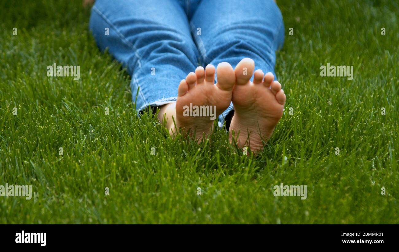 Close-up of a woman raising her feet and stepping on mown lawn Stock ...