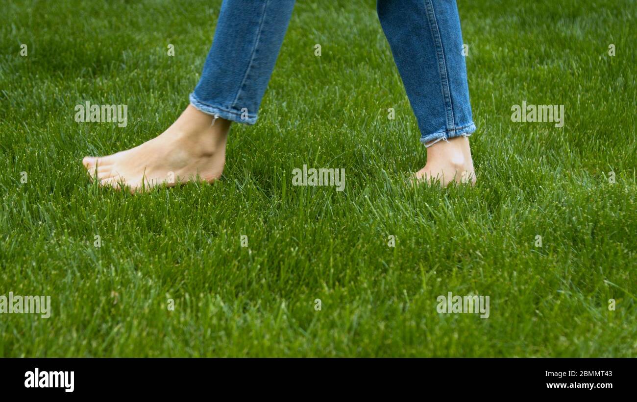 Close-up of a woman raising her feet and stepping on mown lawn Stock ...
