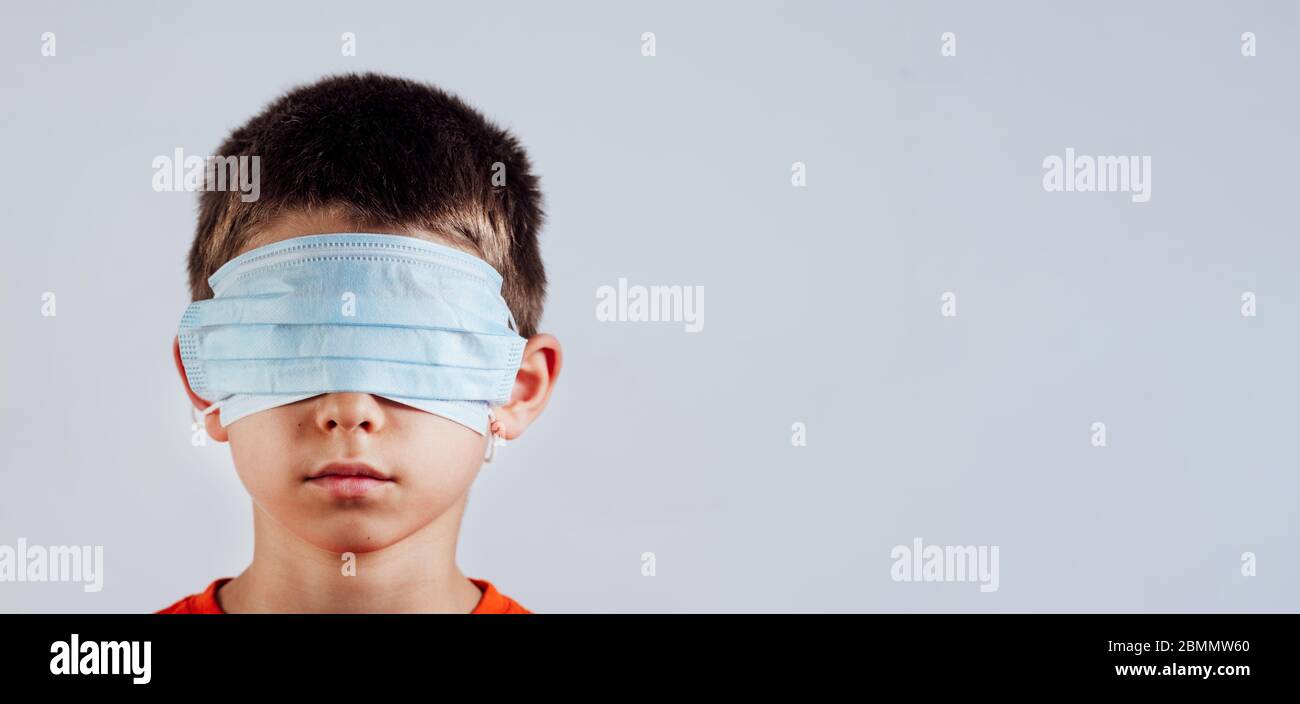 isolated blindfolded child with surgical mask over the eyes and bare ...