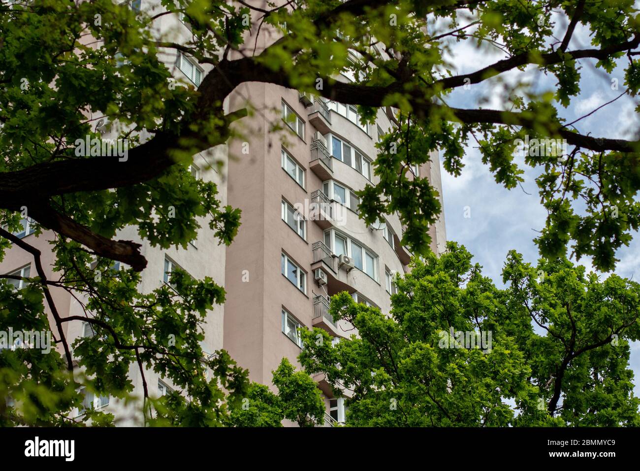 tall apartment building among trees and leaves Stock Photo - Alamy