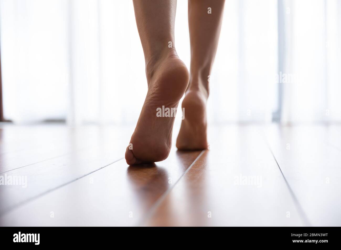 Female feet walks on warm laminate floor closeup rear view Stock Photo ...