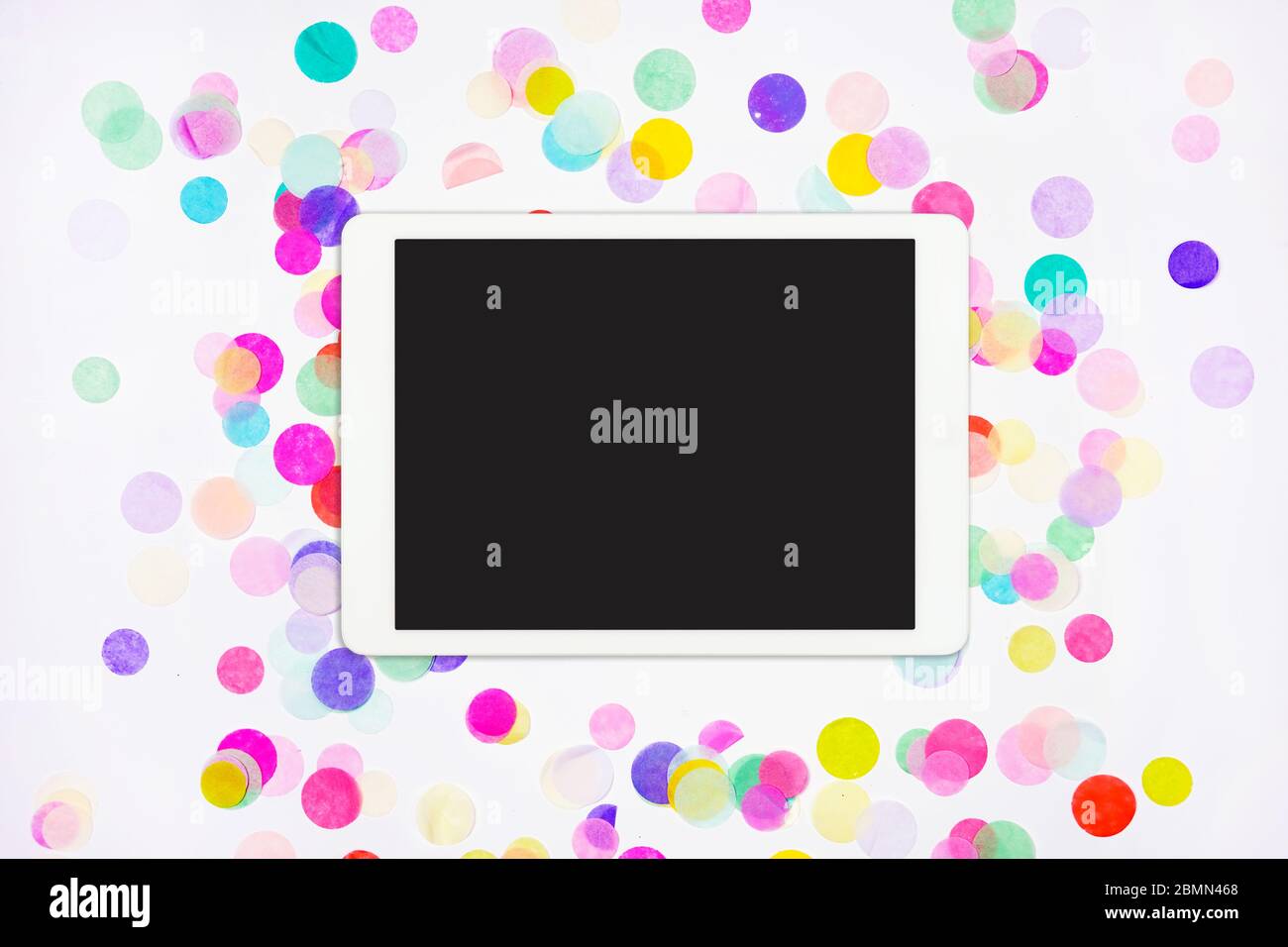Touchpad with blank screen on colorful confetti background. Birthday ...