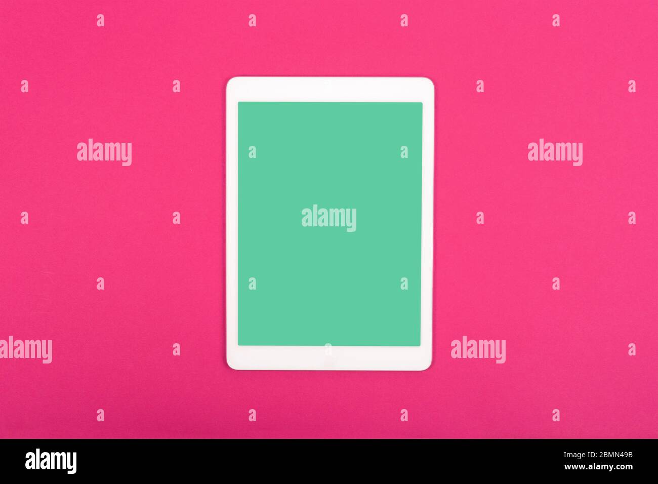 White touchpad with blank green screen on magenta background. Flat lay ...
