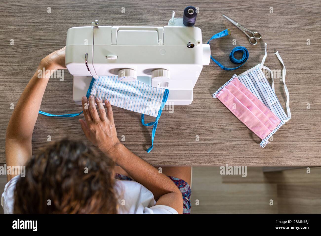 Woman making face masks with a sewing machine at home Stock Photo - Alamy