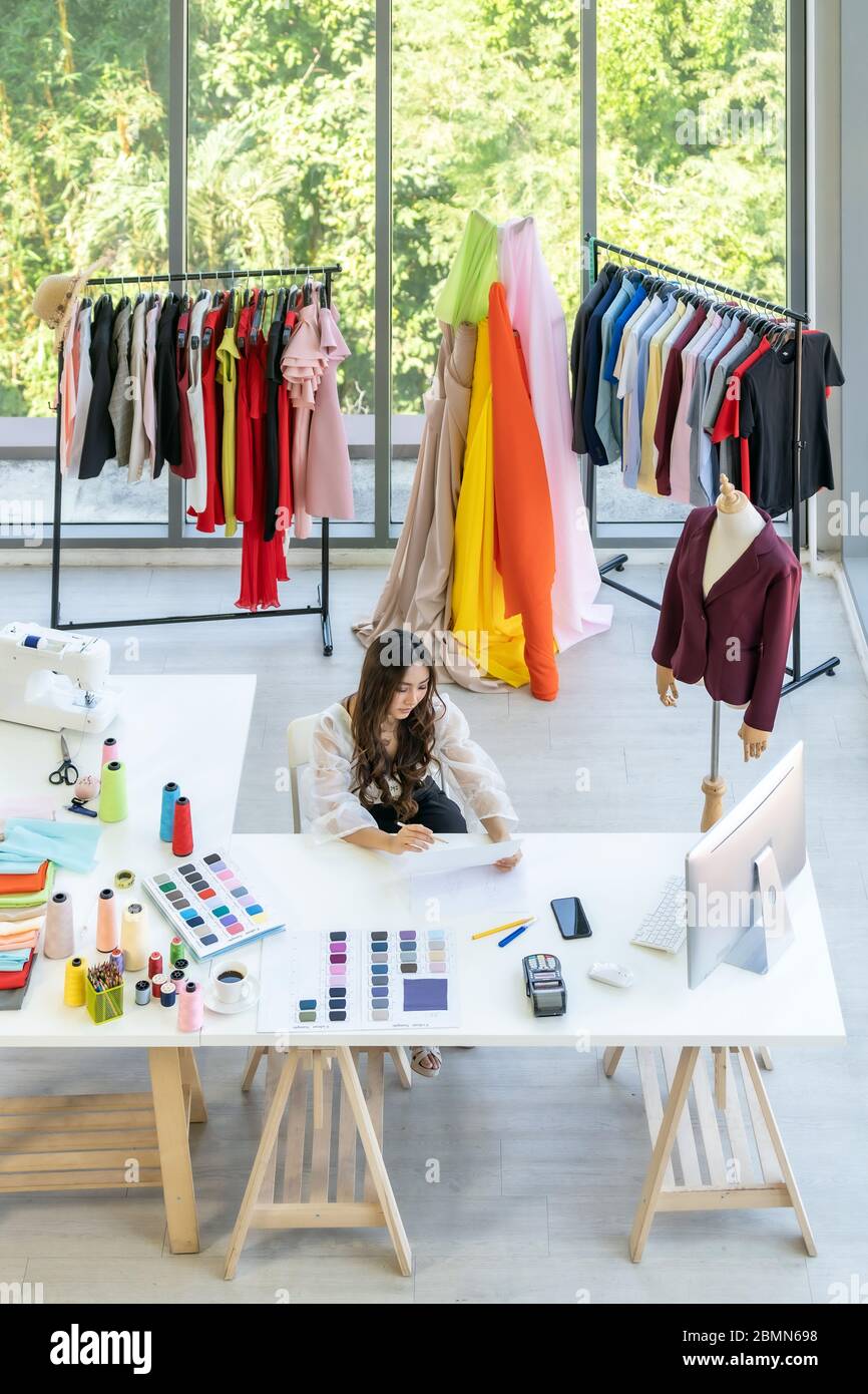 Top view of young adult asian fashion designer drawing and sketching ...