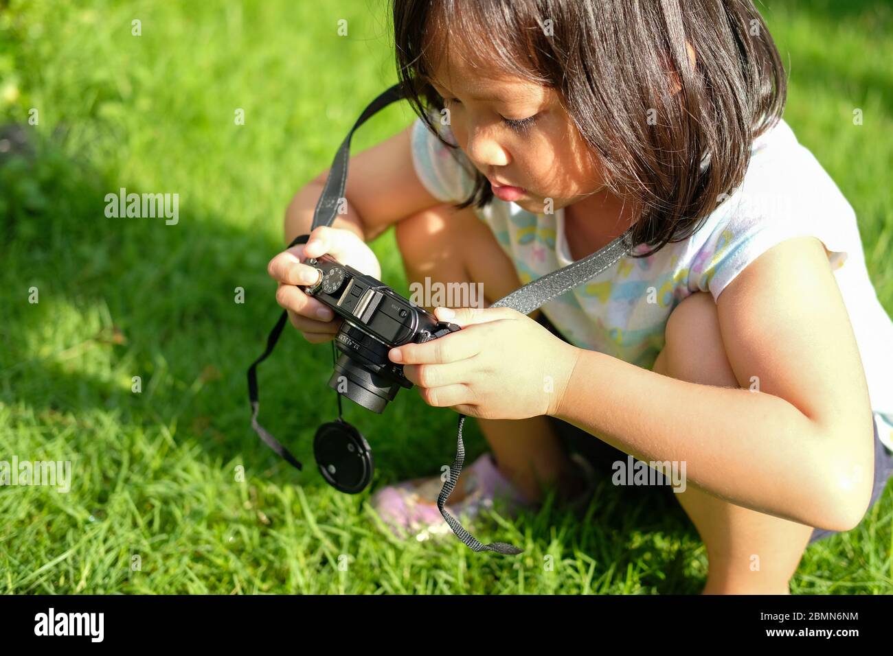 Kid, Child, Asian little girl holding and looking at the digital camera ...
