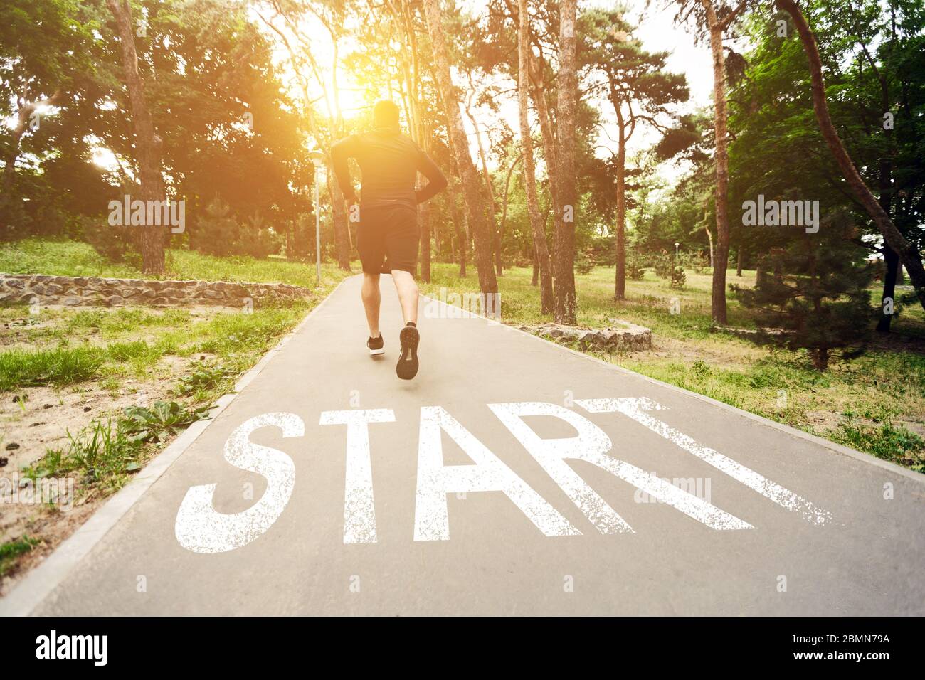 Rear View Of Athlete Passing Start Lettering On Running Path Outdoors ...