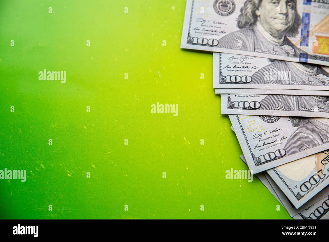 Stack of hundreds of dollars on bright green background with copy space ...