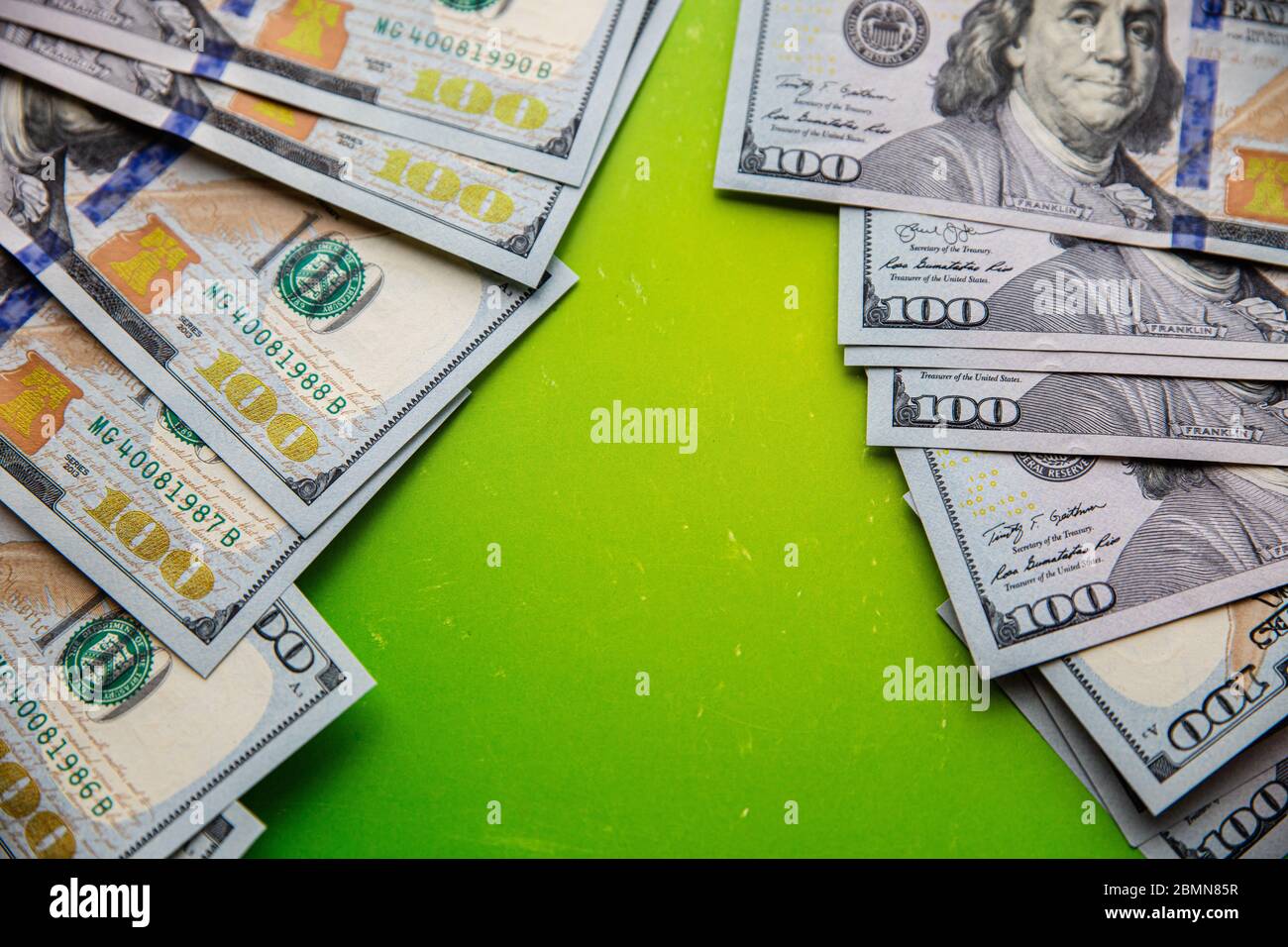 Stack of hundreds of dollars on bright green background with copy space ...