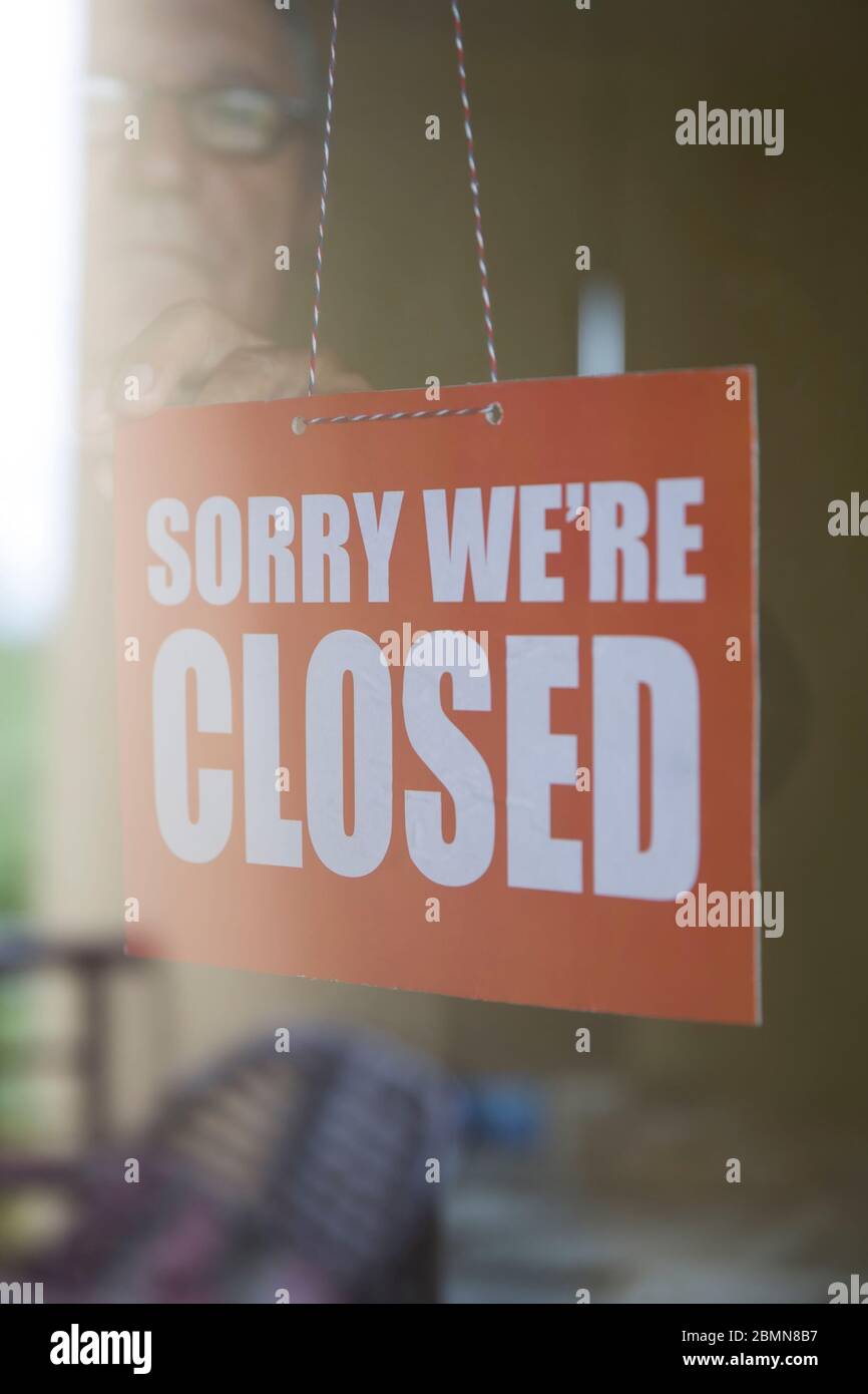 Closed sign board hanging on the glass door of cafe or small store ...