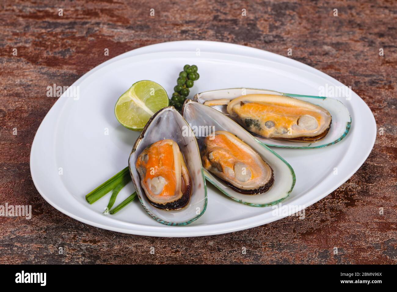 Half mussels with lime and green pepper Stock Photo - Alamy