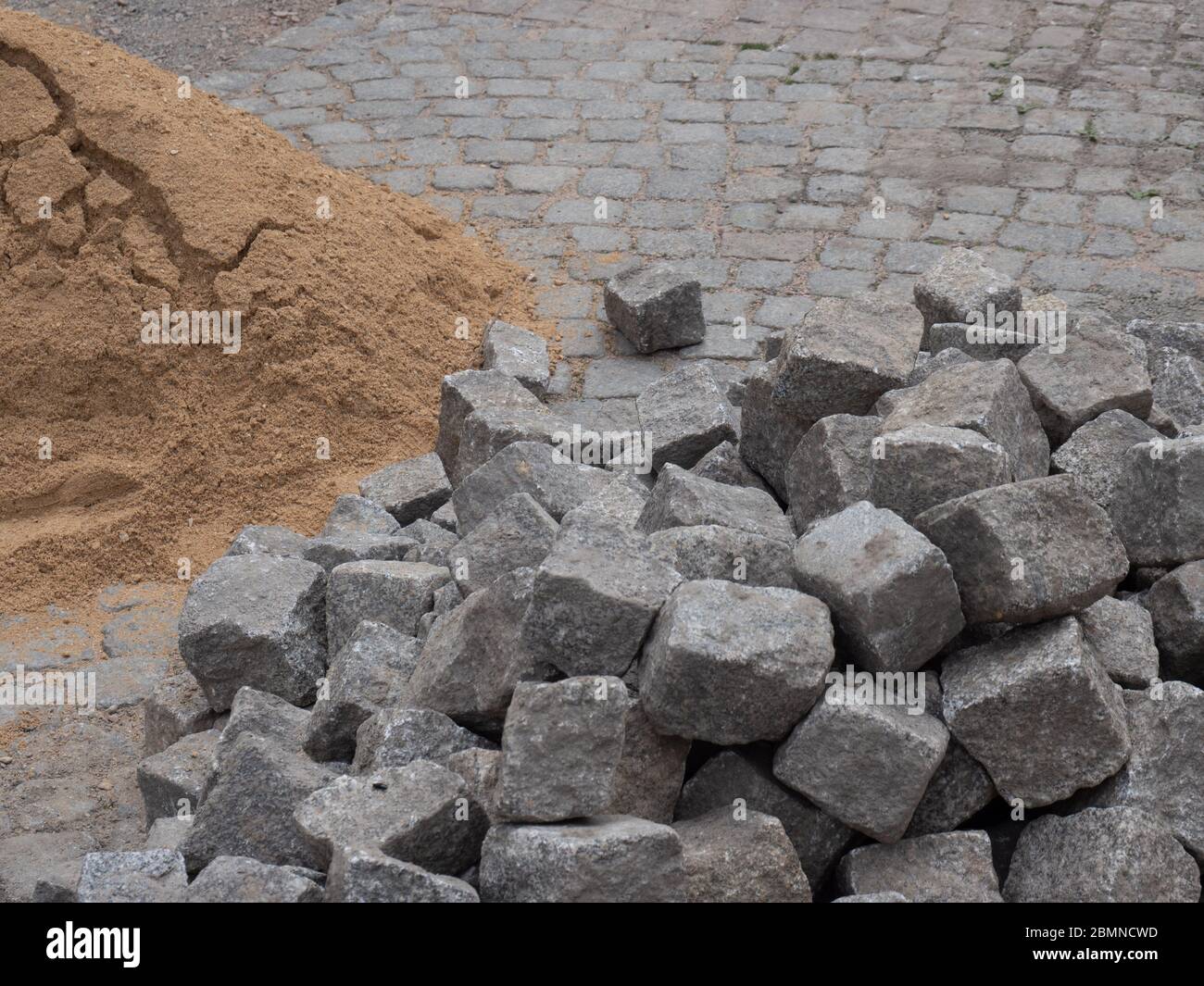 Paving stones and piles of sand road construction Stock Photo - Alamy