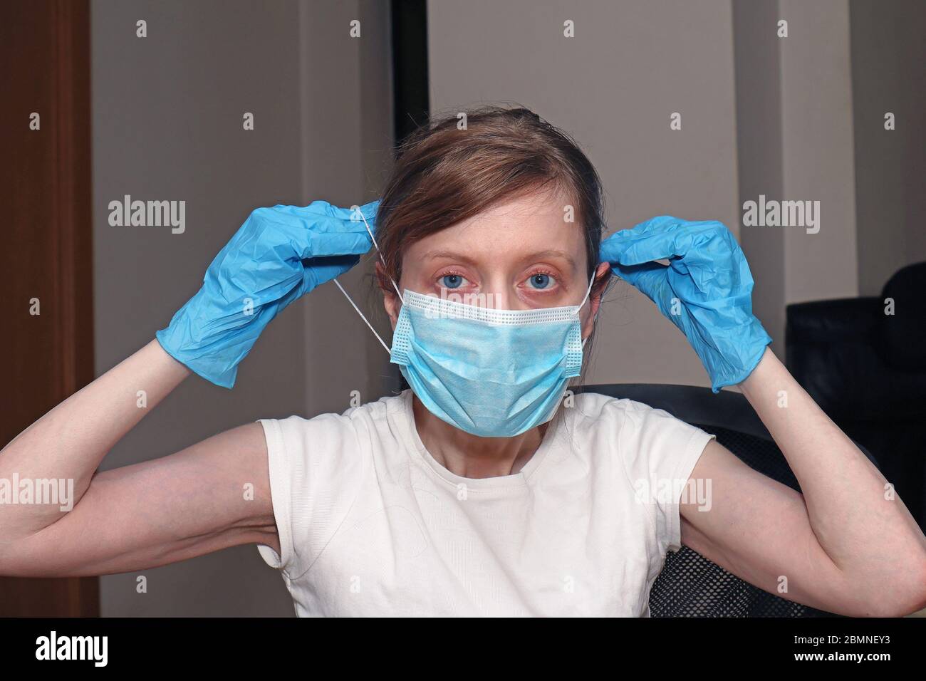 Young woman putting mask over face with rubber gloves for virus ...