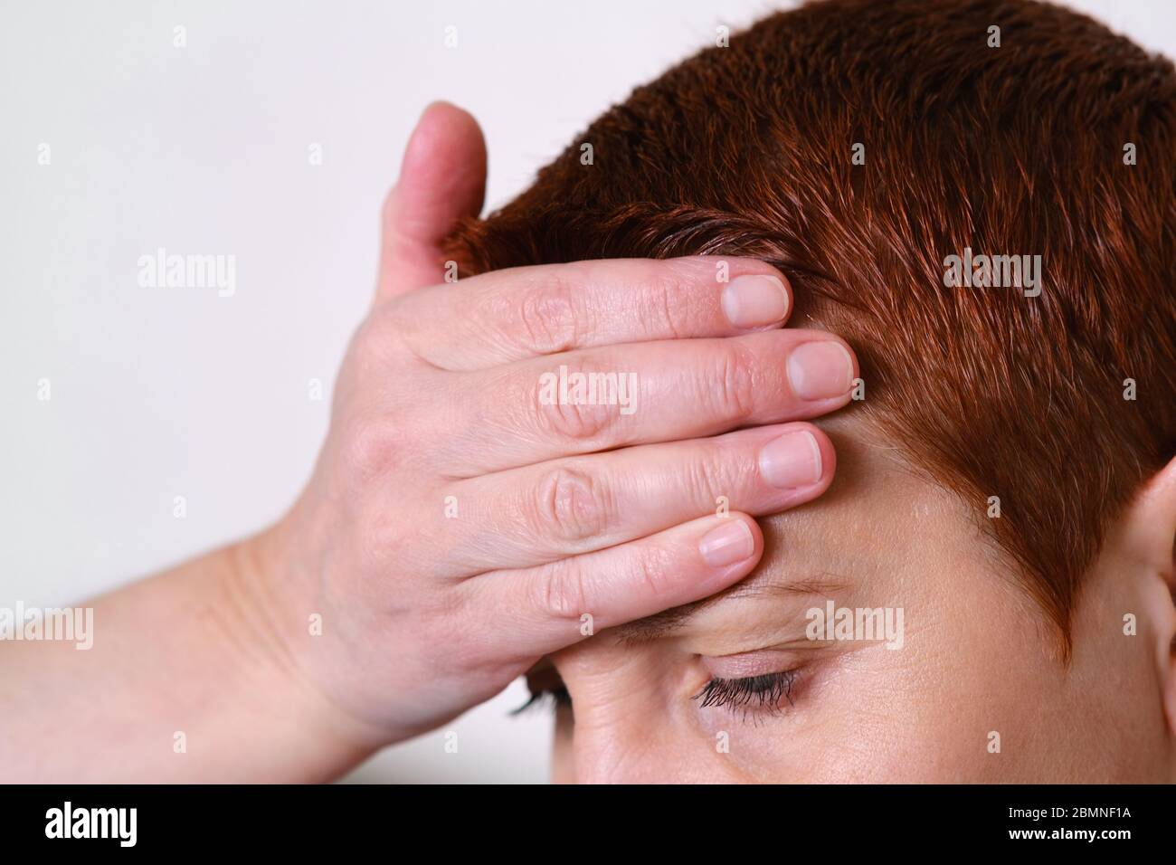 The woman put her hand to her forehead, experiencing a headache ...