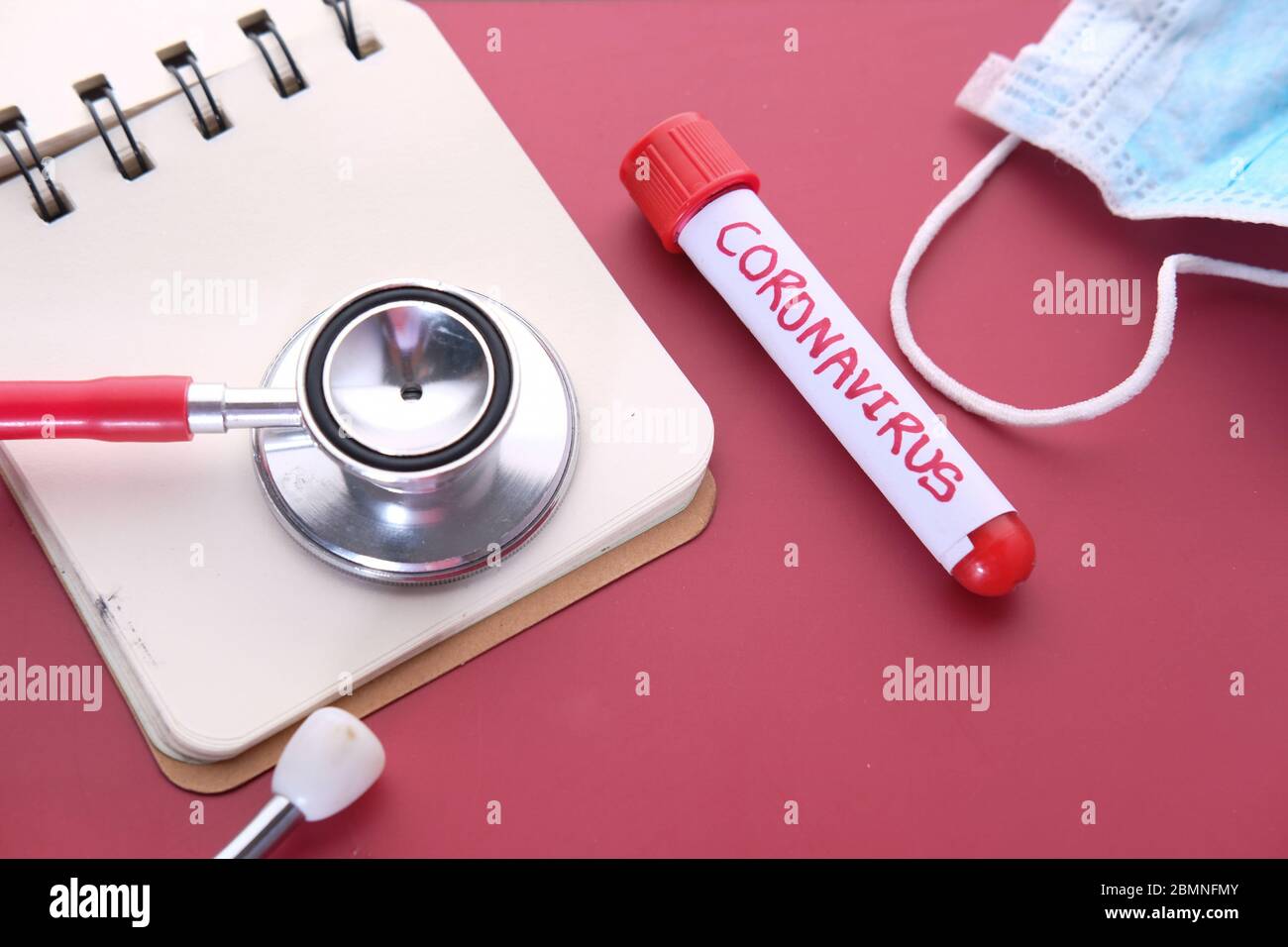 blood test tube, mask and stethoscope on red background Stock Photo - Alamy