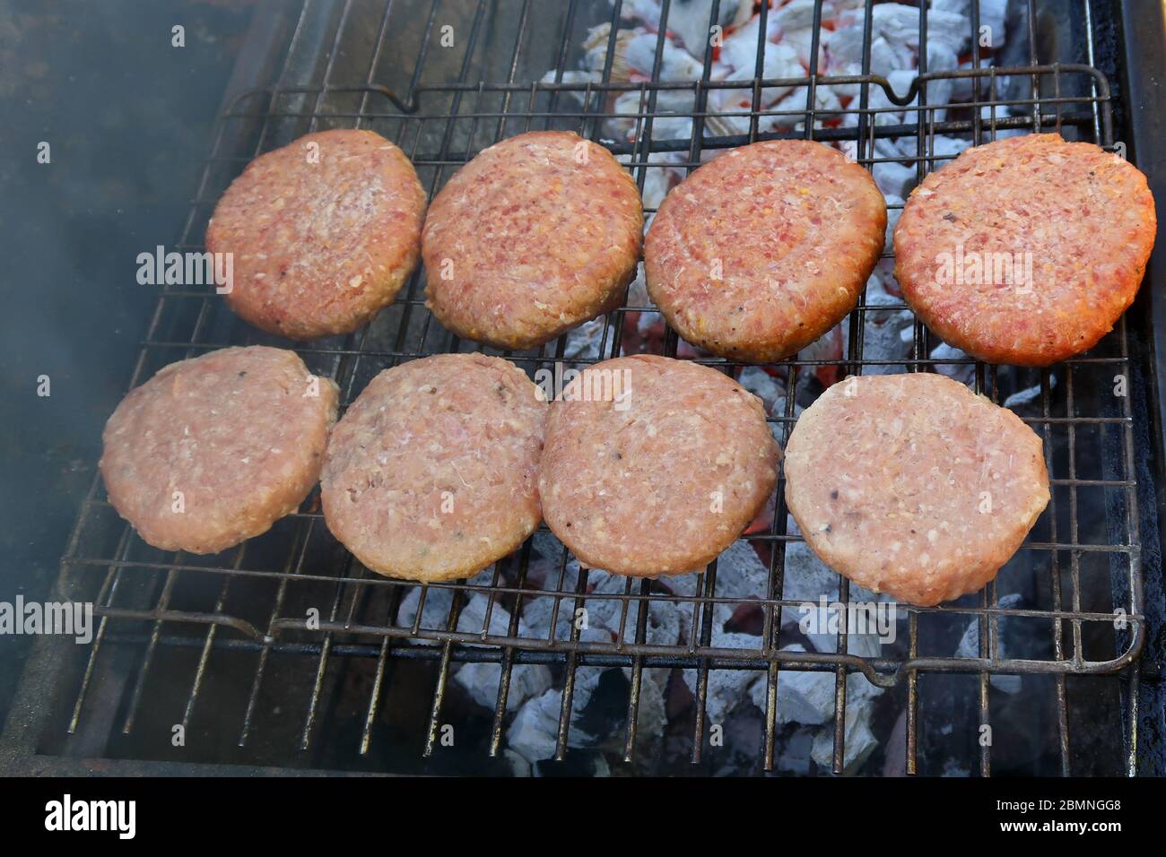 A tasty scene with Burgers cooking on the barbeque Stock Photo - Alamy