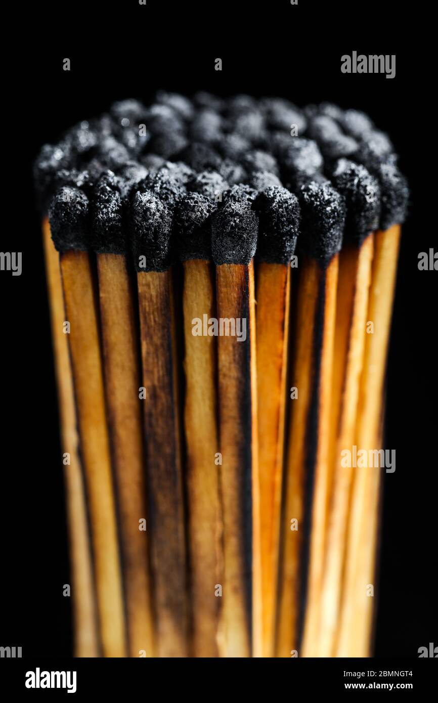 Burnt matchsticks in front of black background Stock Photo - Alamy
