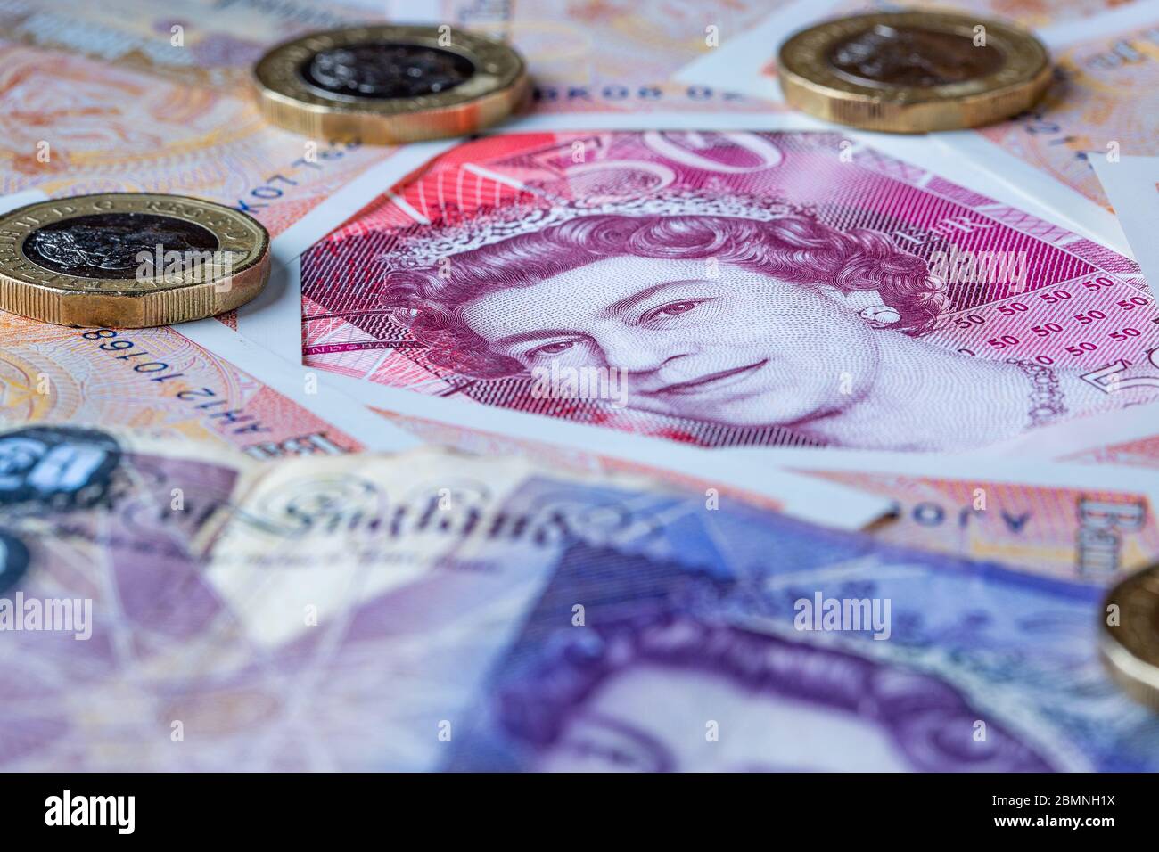 Fifty Pound note surrounded by Ten and Twenty Pound Notes with some one ...