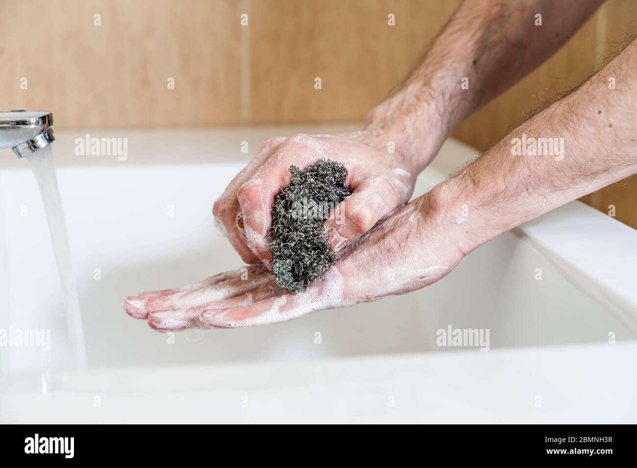 Man cleaning his hands with soap and a steel scourer Stock Photo - Alamy