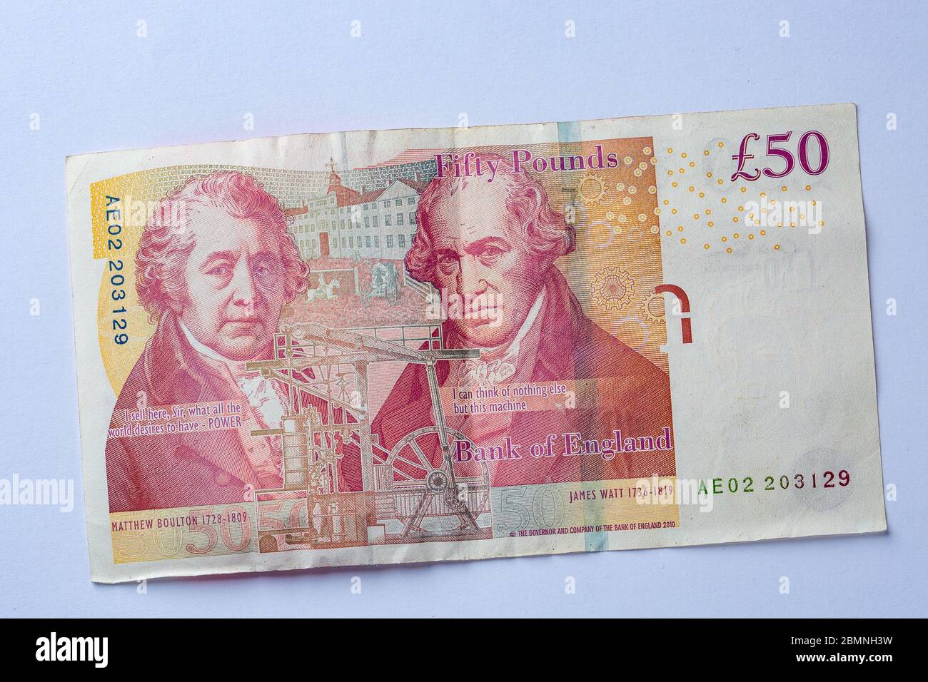 A Fifty pound note laying flat on a plain white background, £50 cash ...