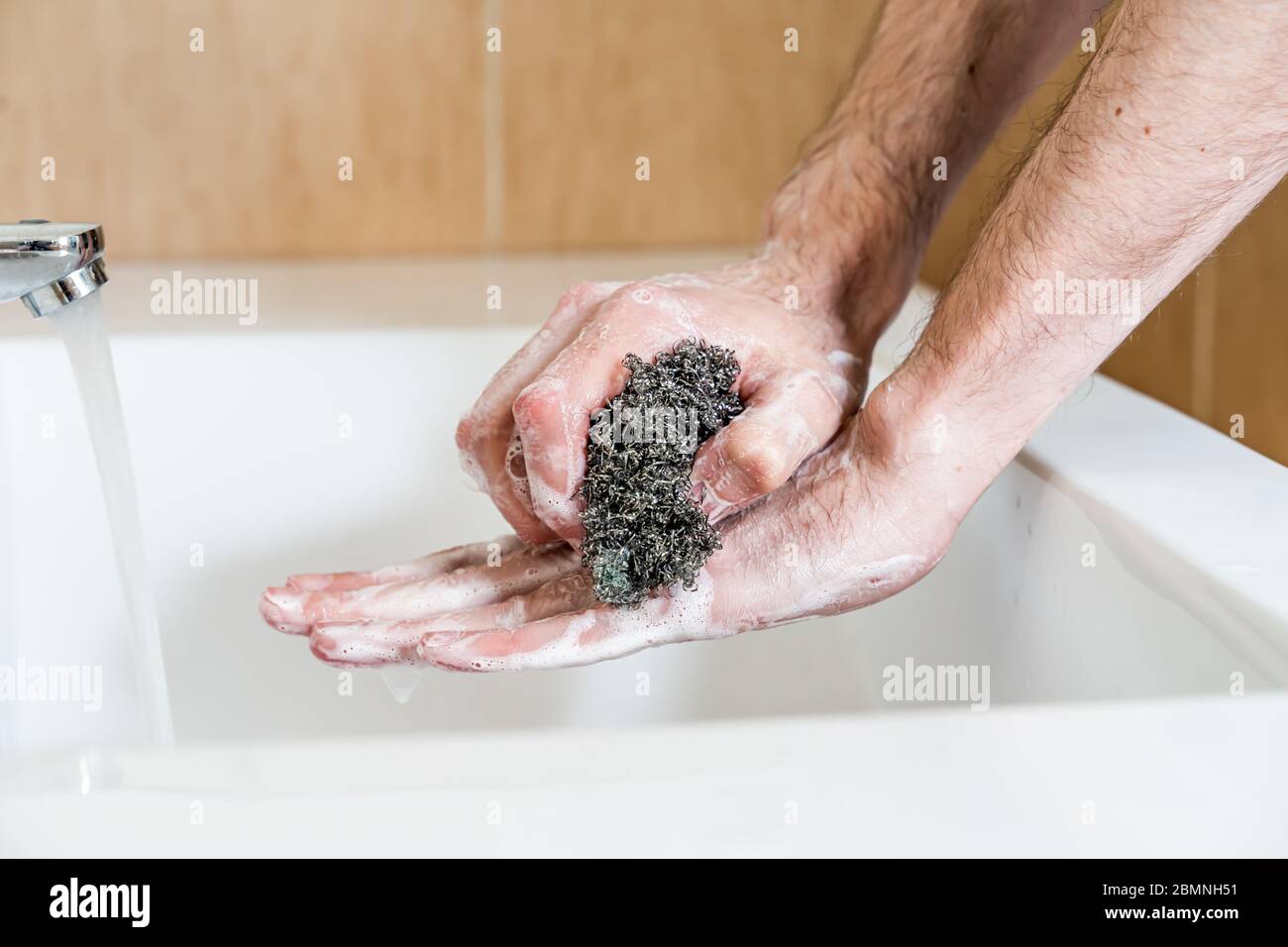 Man cleaning his hands with soap and a steel scourer Stock Photo - Alamy
